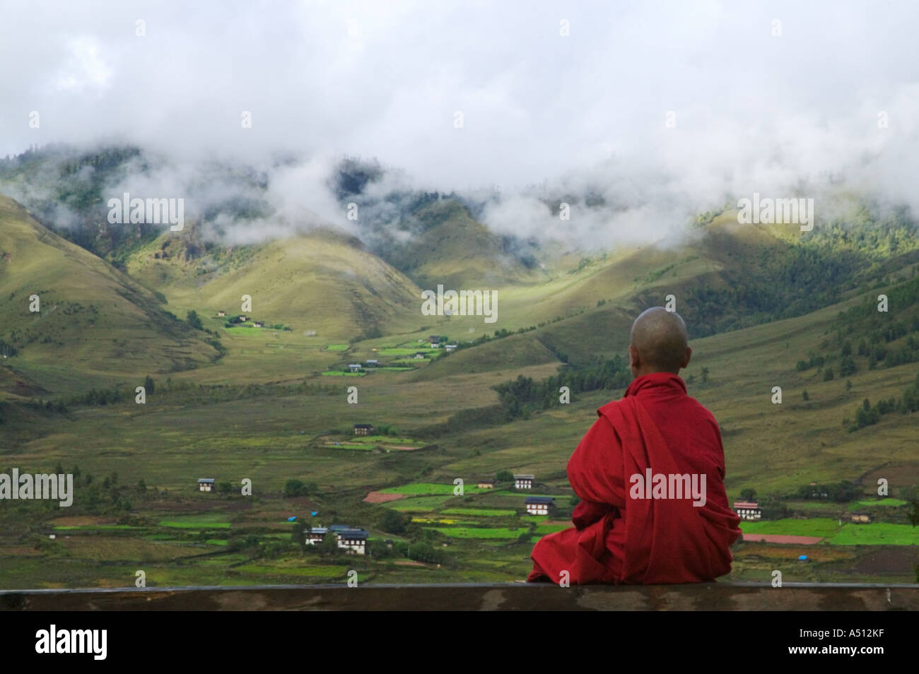 Monk with village houses and farmlands in the Phobjikha Valley Bhutan ...