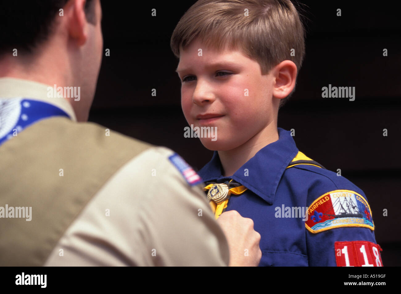 Boy Scout straightening neckerchief of Cub Scout User needs to obtain ...