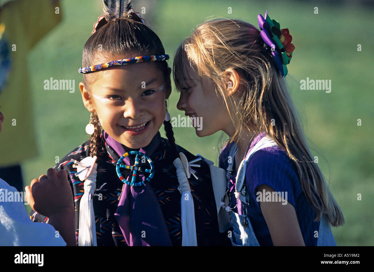 Indigenous Native American girl in ceremonial dress with Caucasian girl ...