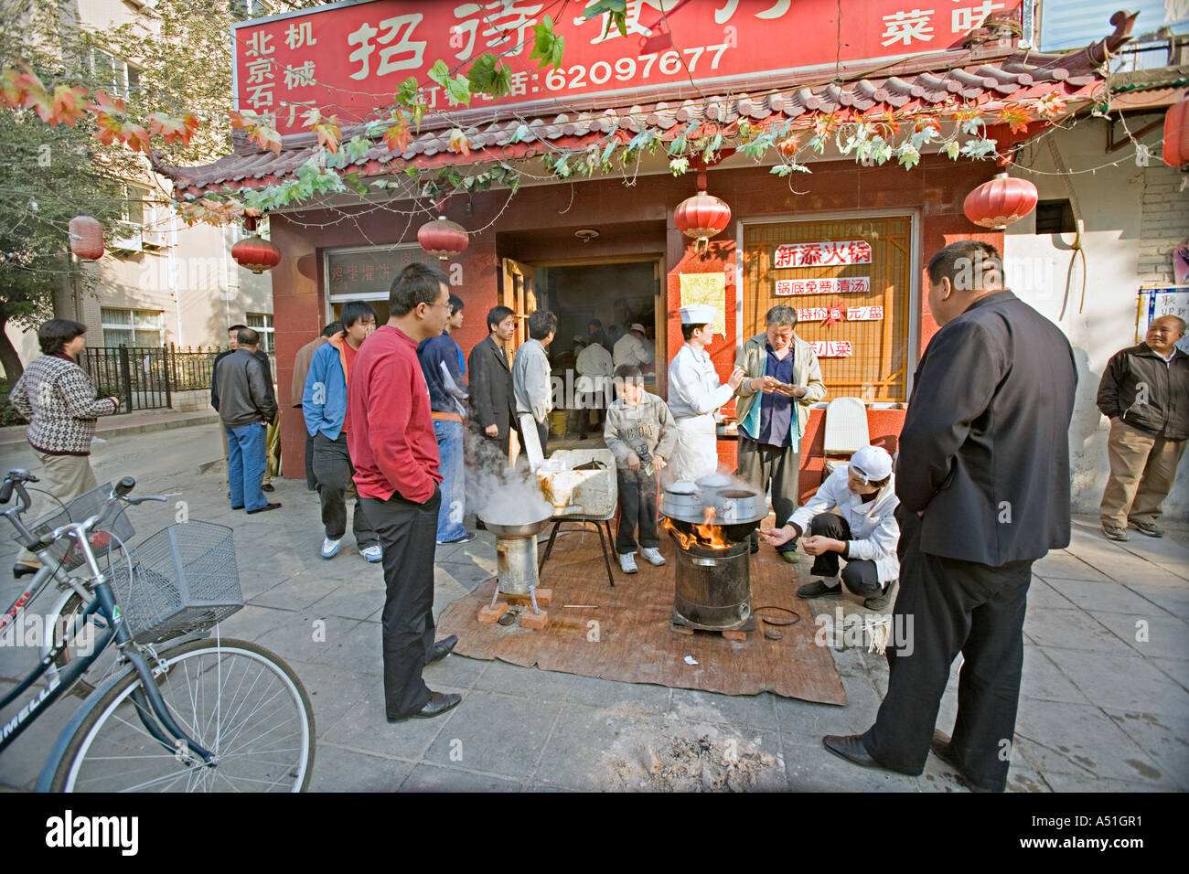 CHINA BEIJING Tiny but busy neighborhood restaurant with chefs set up ...