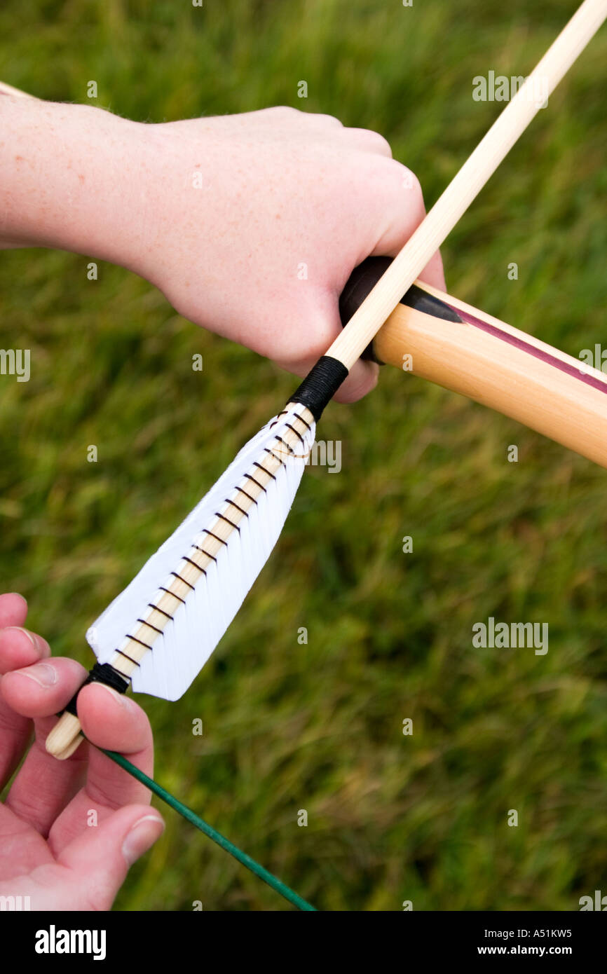 nocking mounting the arrow to wooden bow Stock Photo - Alamy