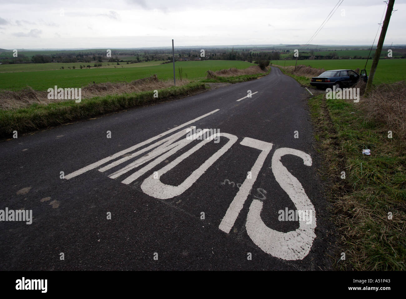 Warning sign painted on tarmac road surface SLOW Stock Photo - Alamy