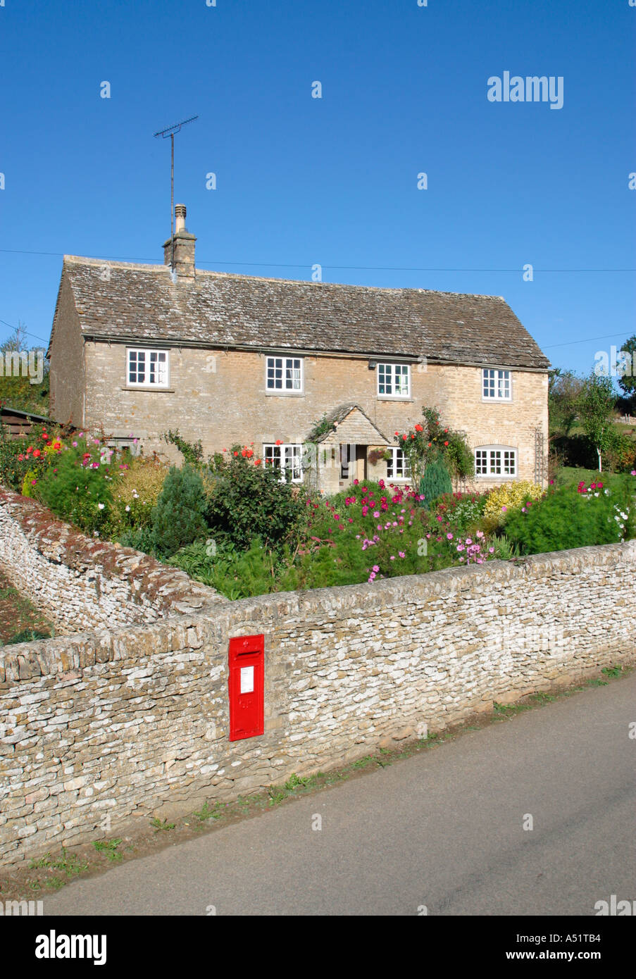 Vibrant red post boxand acotswold cottage, Coln Rogers, Cotswolds ...