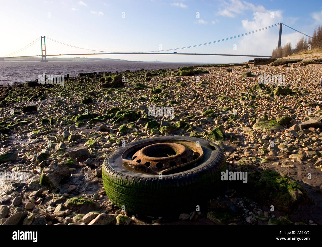 The Humber Bridge with a cars tire that has washed up on the shore ...