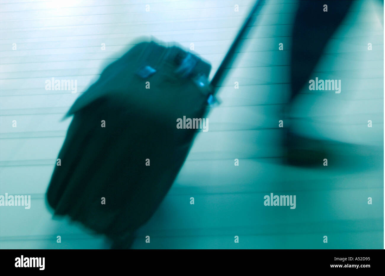 Pulling suitcase thru airport Stock Photo - Alamy