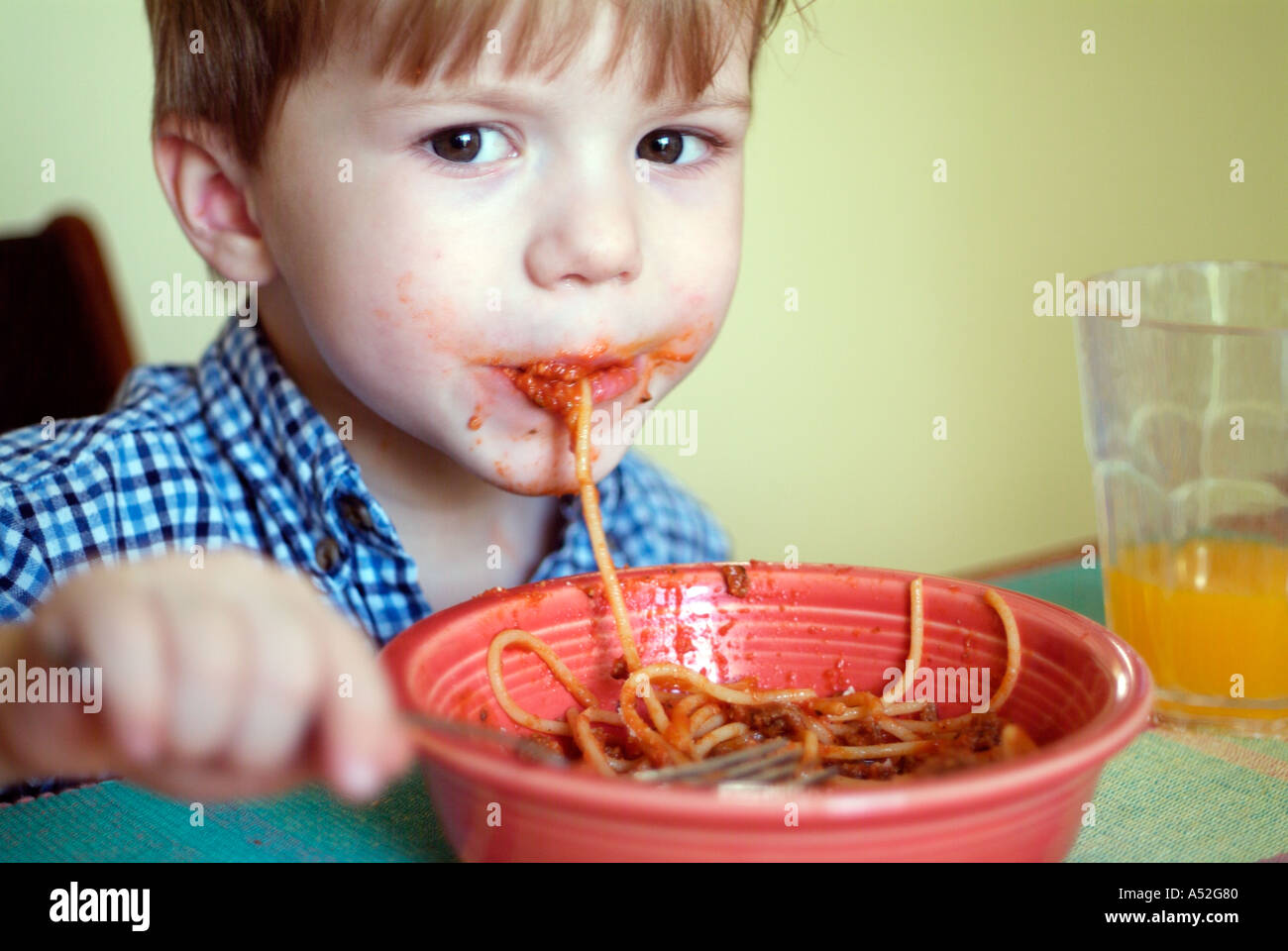 Boy eating messy spaghetti dinner from bowl sloppy manners child ...