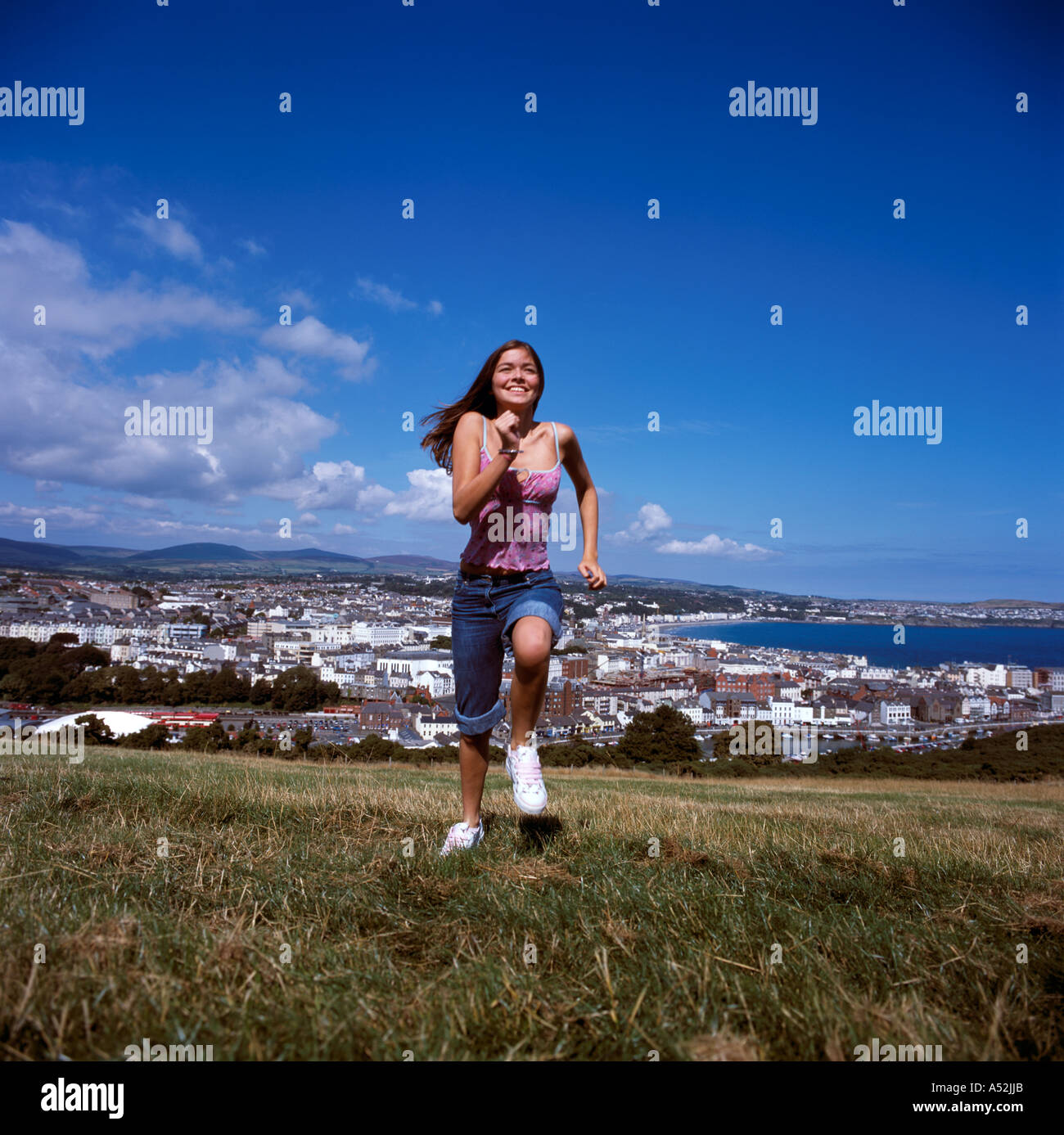 Teenage girl running through a field Stock Photo - Alamy
