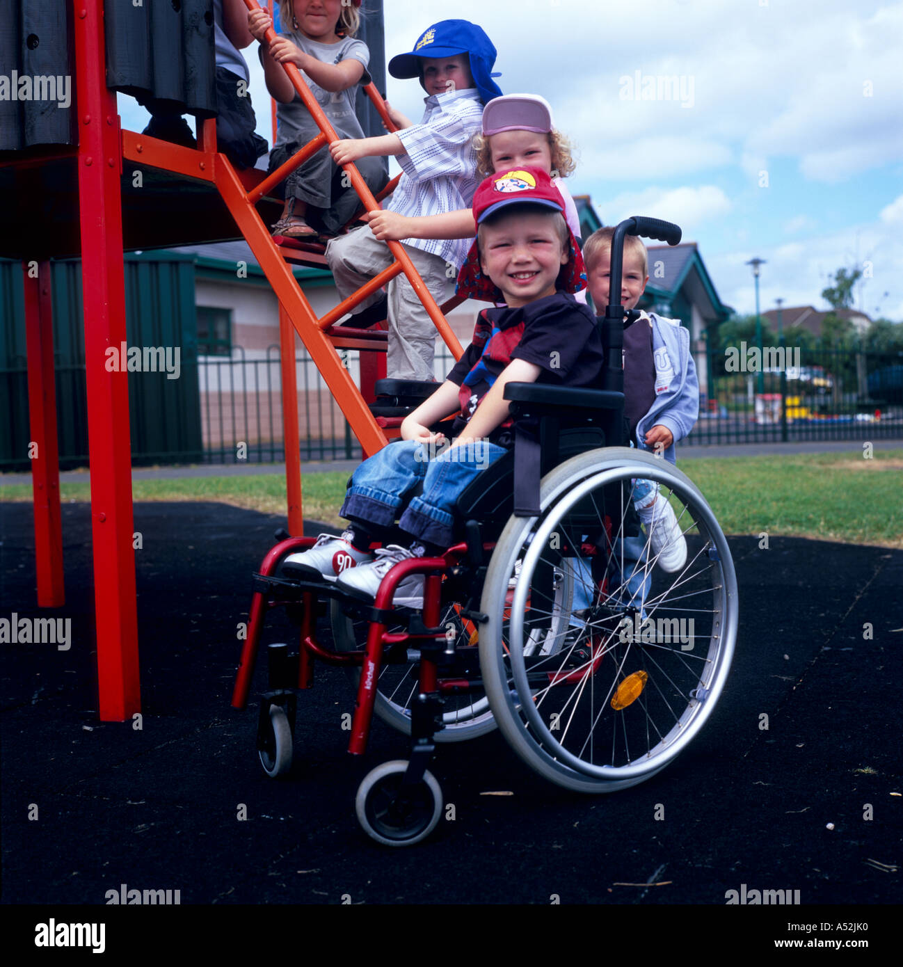 Disabled boy aged 7 years in wheelchair playing in school play ground ...