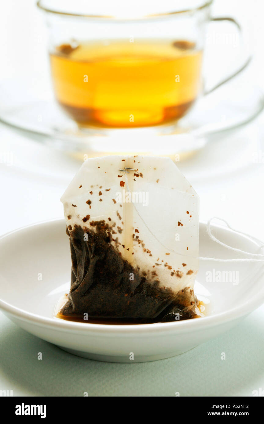 Used tea bag in front of teacup Stock Photo - Alamy