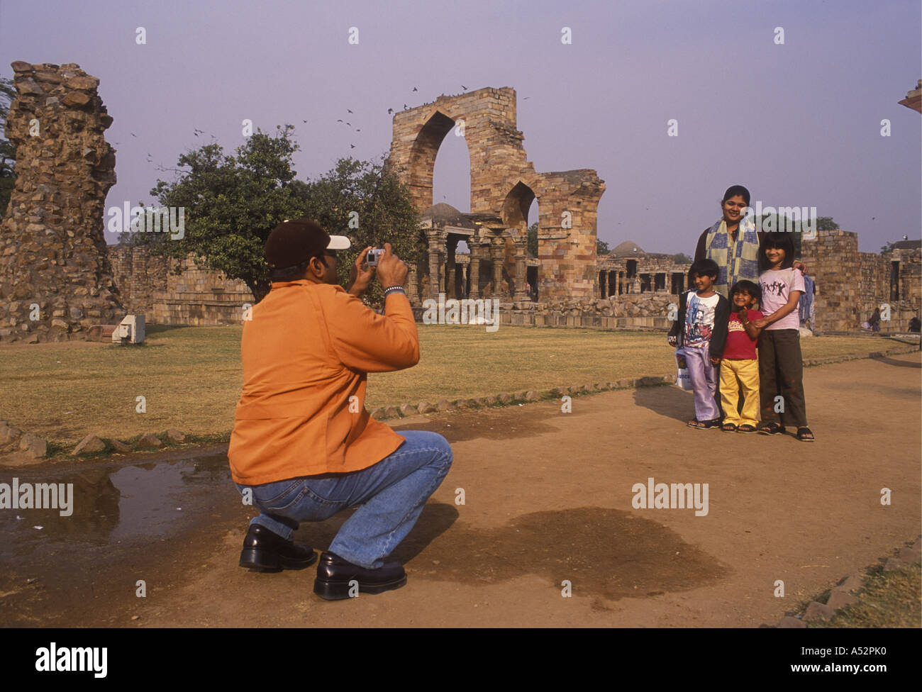 A proud Indian father photographing his family with a digital camera at ...