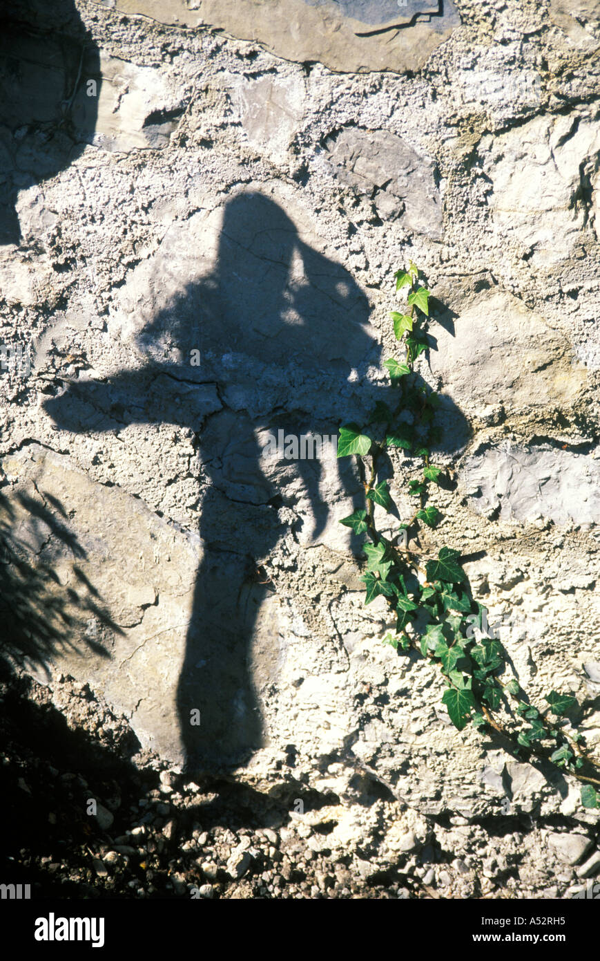 Shadow of a cemetery cross at a stone wall Stock Photo - Alamy