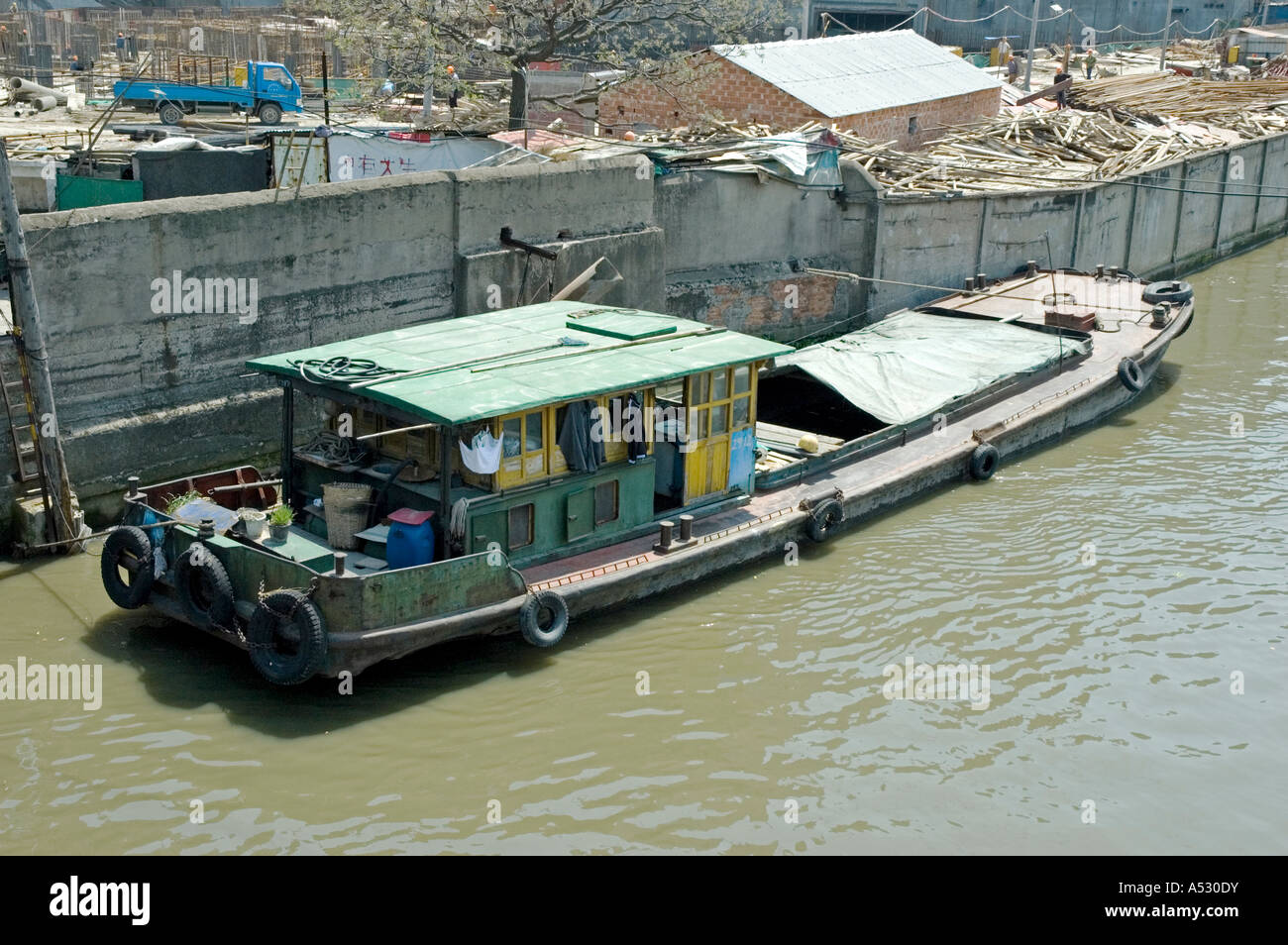 Barge moored alongside a construction site, Shanghai Stock Photo - Alamy