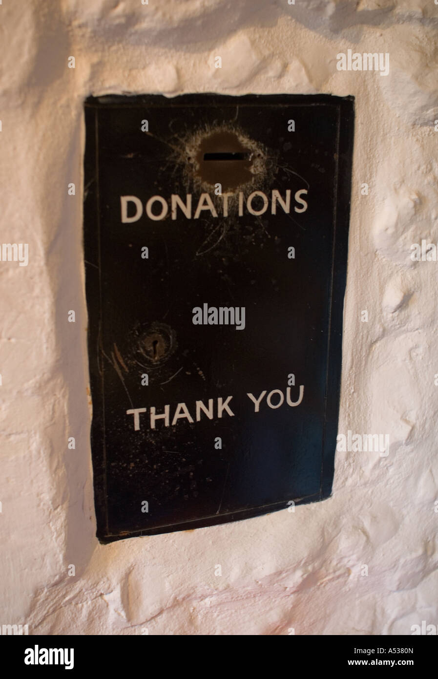 A charity collections box inside a church with a notice saying ...