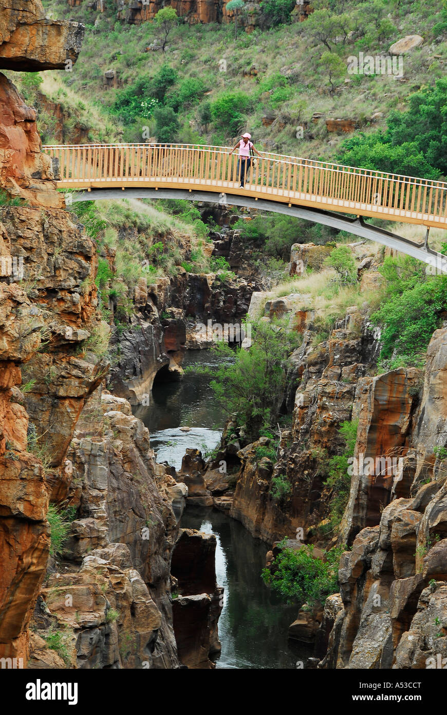Tourist on foot bridge over Treur River, Bourke's Luck Potholes ...