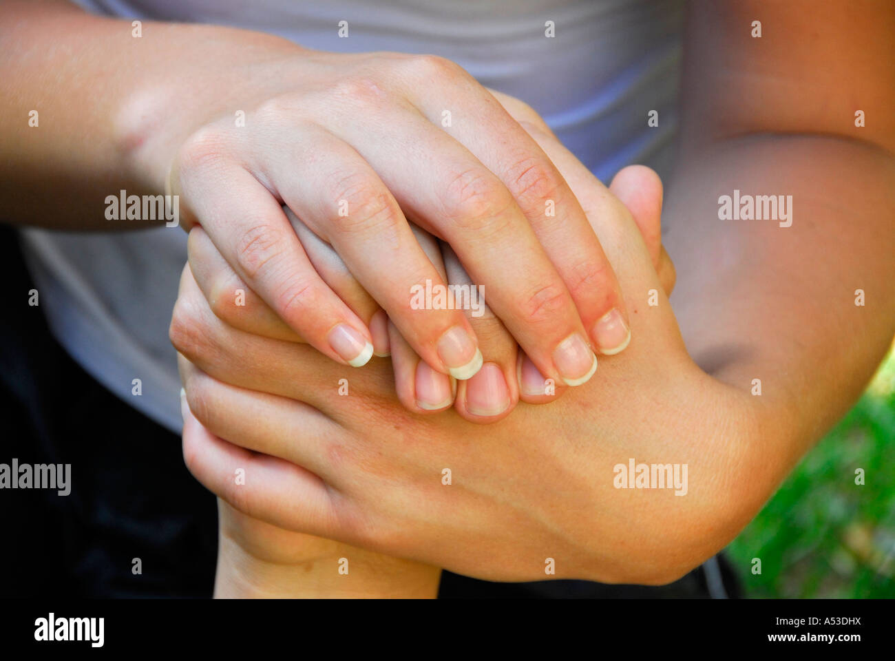 Girl clasping friend's hand very tightly to help him through pain after ...
