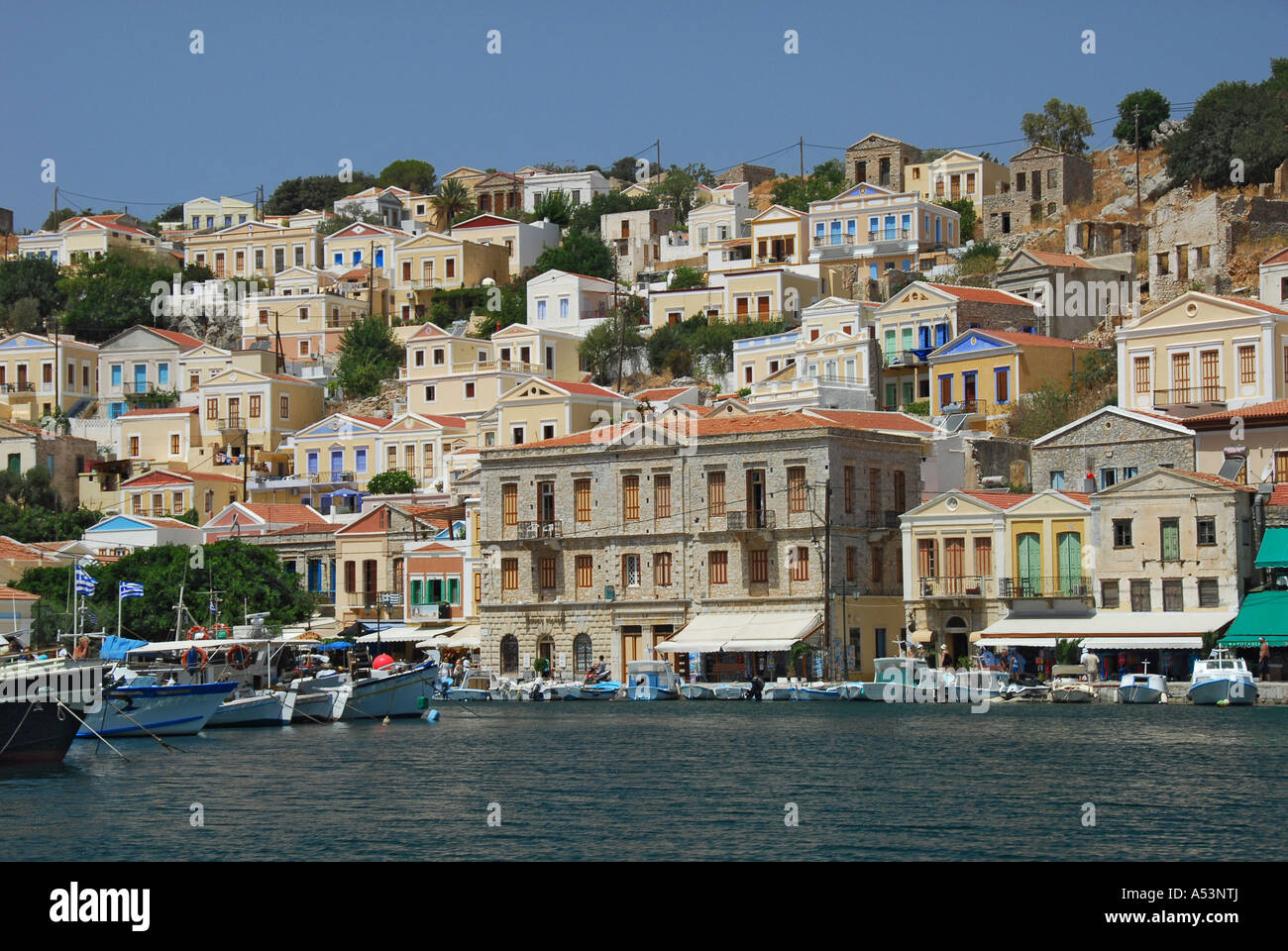 Neo-Classical houses on the hillside above Yialos harbour in Symi Town ...