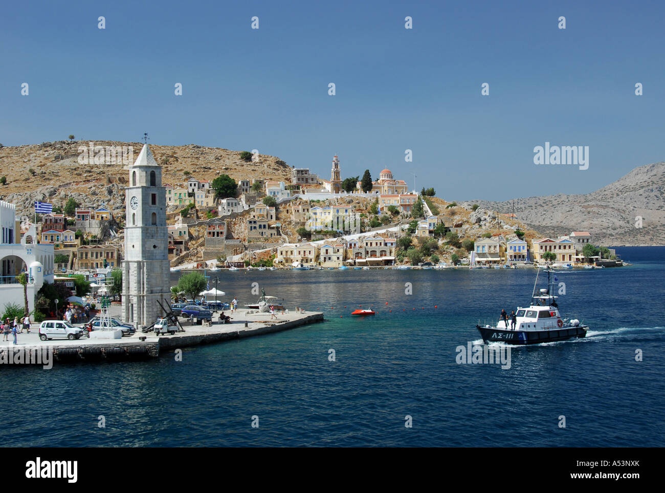 A Greek Coast Guard patrol boat approaches the harbour entrance to Sými ...