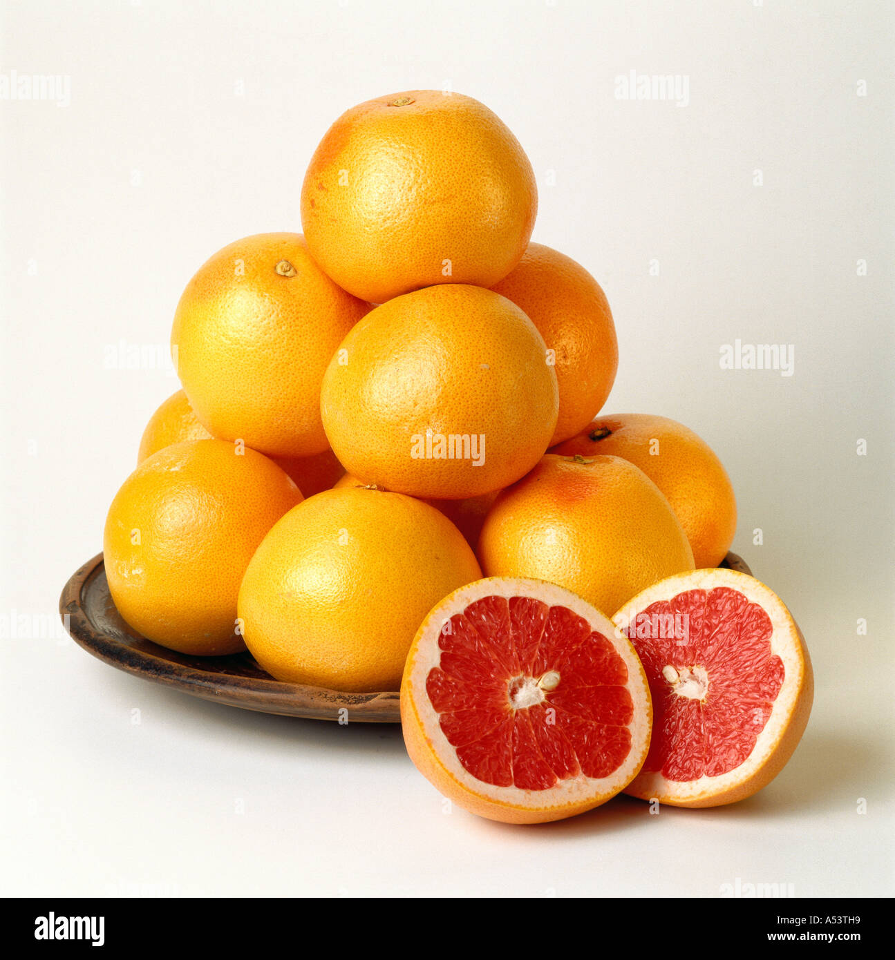 Pink grapefruits on plate one cut open in front Stock Photo - Alamy
