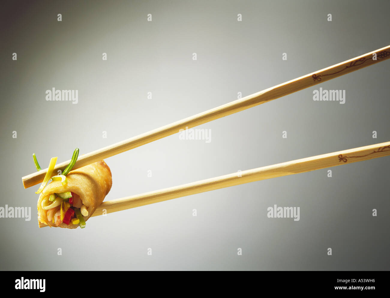 Chopsticks with spring roll Stock Photo - Alamy