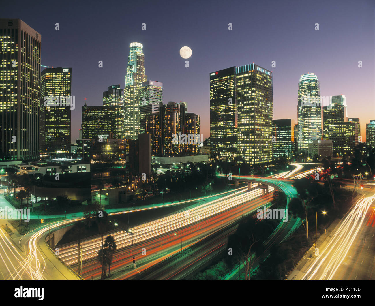 Full moon over Los Angeles Civic Center skyline with palm trees and ...
