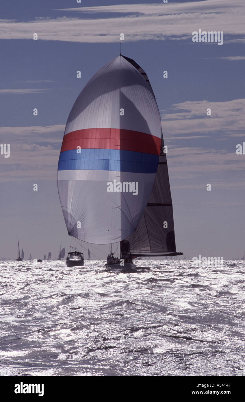 A yacht racing under spinnaker , in the Solent, off the Isle of Wight ...