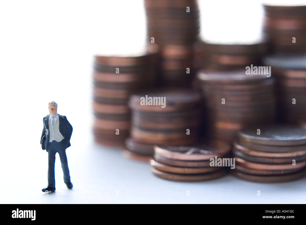 Business figure standing in front of many stacks of pennies Stock Photo ...