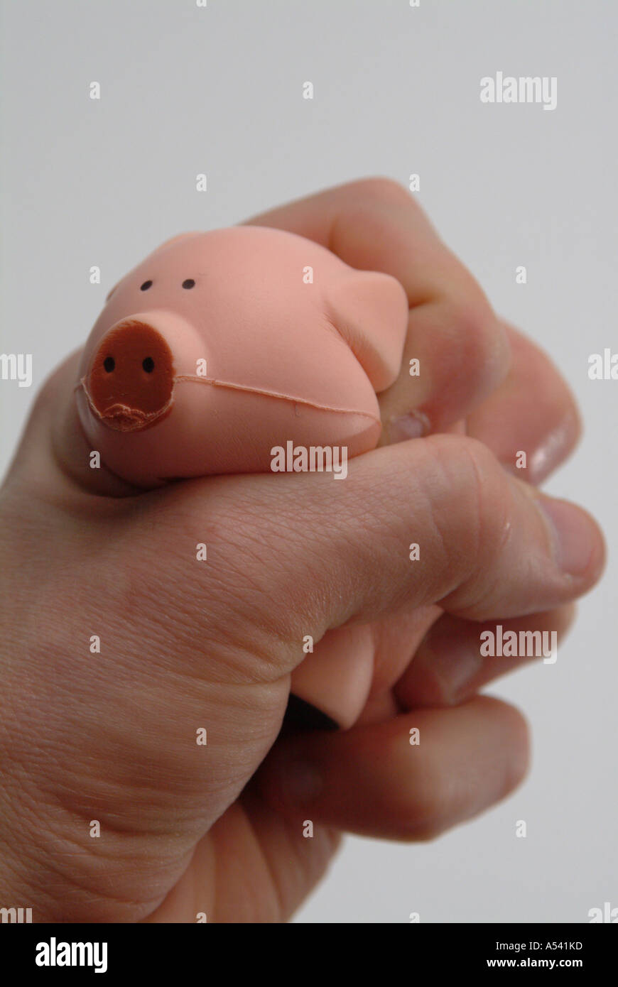 Hand squashing a stress toy pig Stock Photo - Alamy