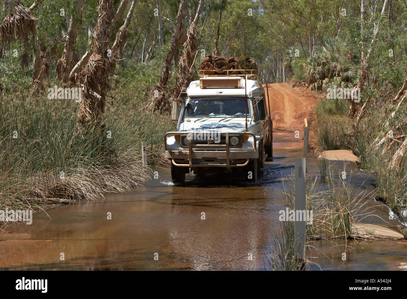 Toyota Landcruiser drives through a ford across Fortescue river Pilbara ...