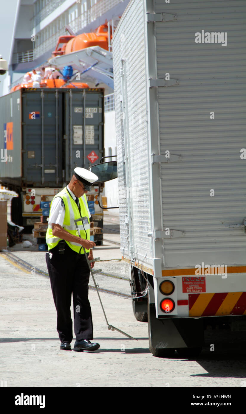 Security officer using mirror to inspect underside of a lorry Security ...