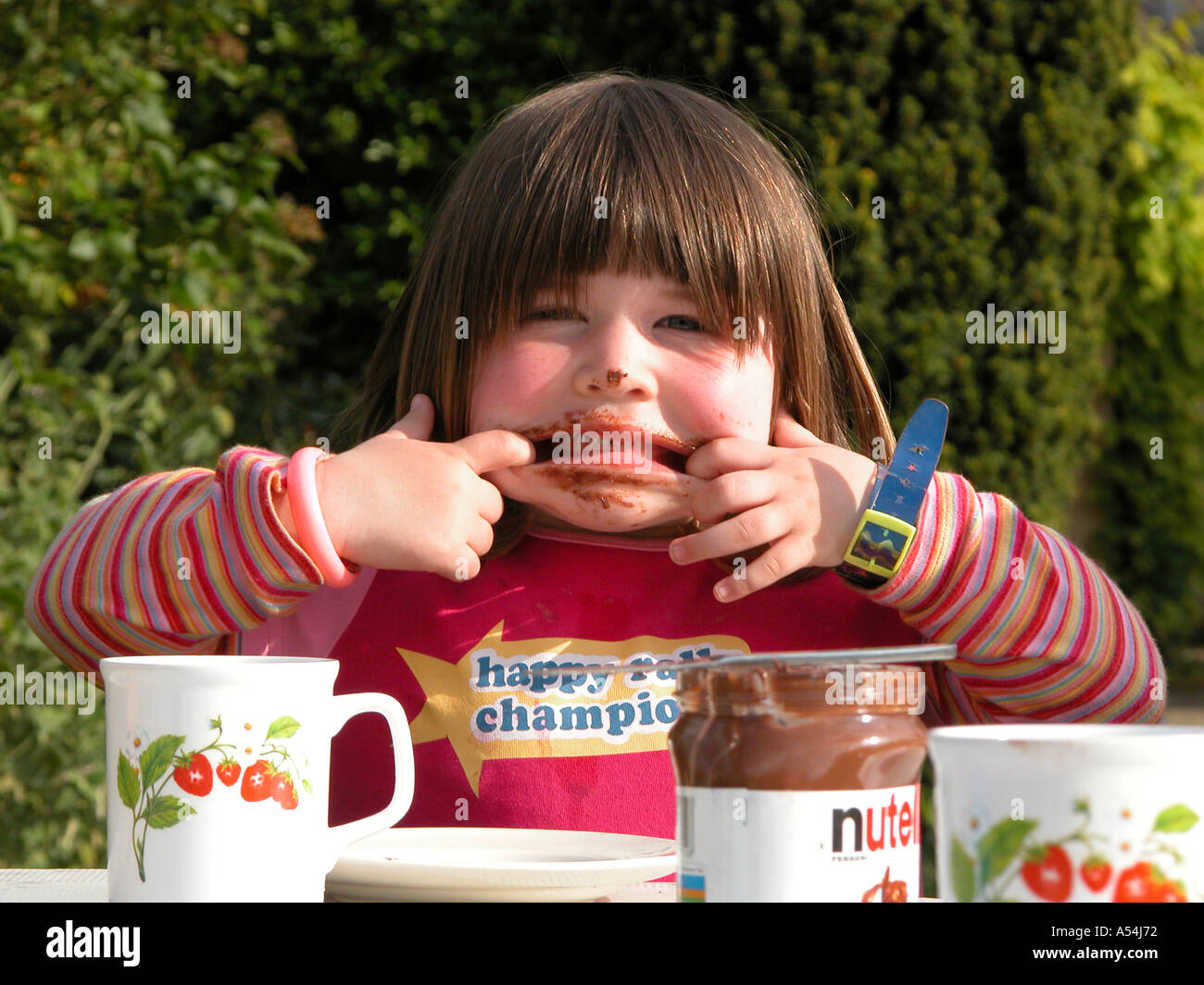 Little girl eating chocolate Stock Photo - Alamy