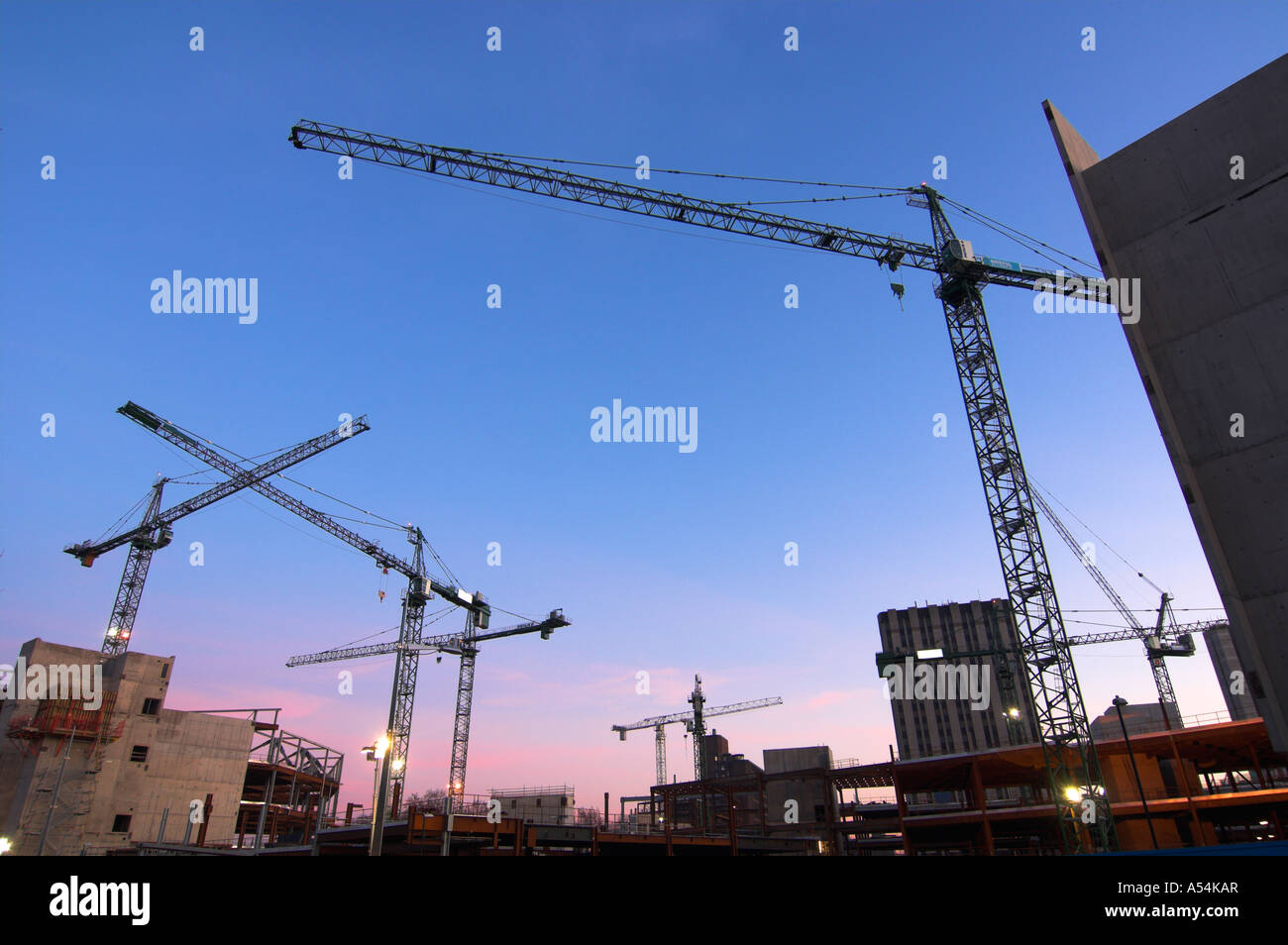 Multiple construction cranes against blue sky at building site Stock ...