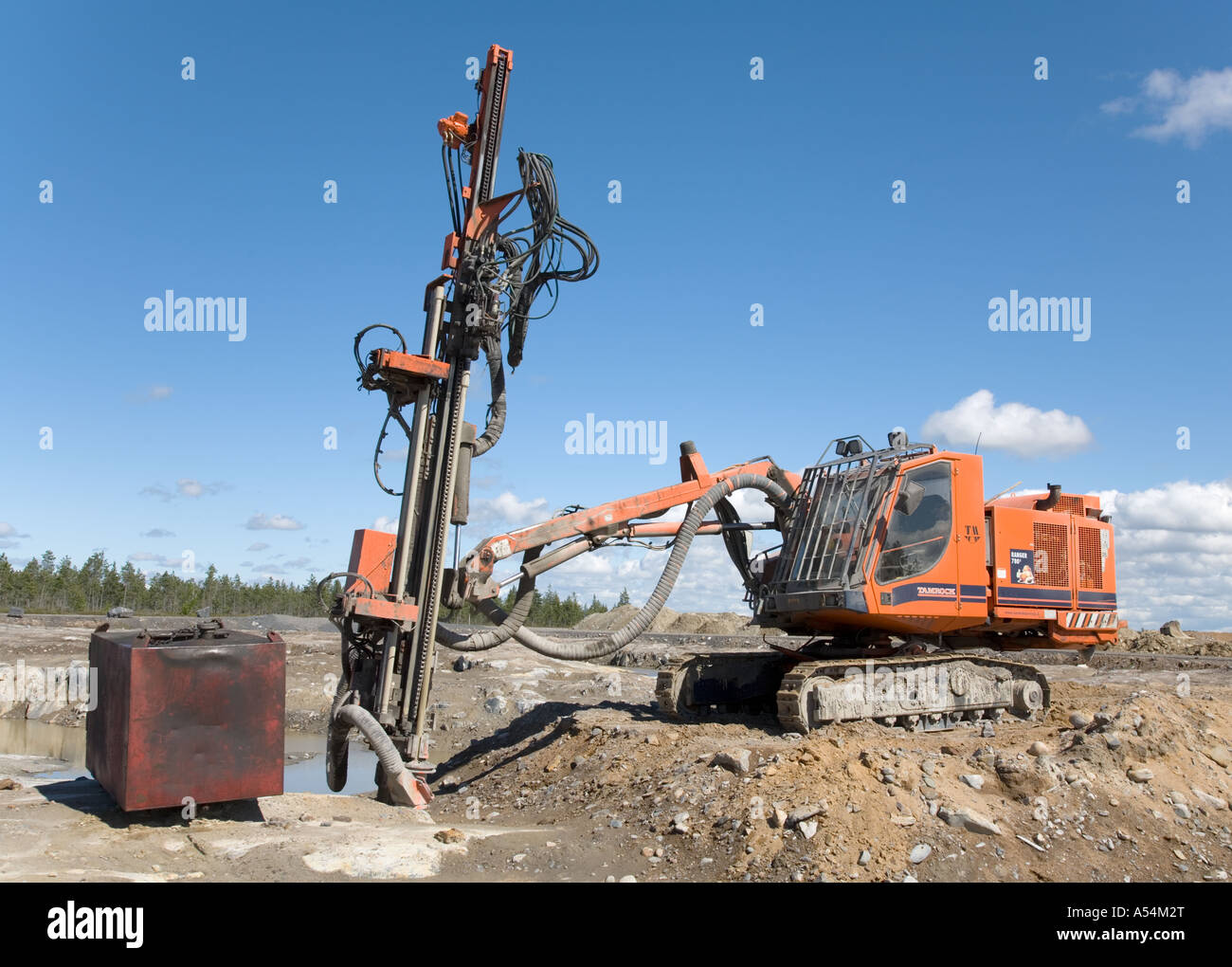 Orange Tamrock Ranger 780 rock drill machine in a rock quarry ready to ...