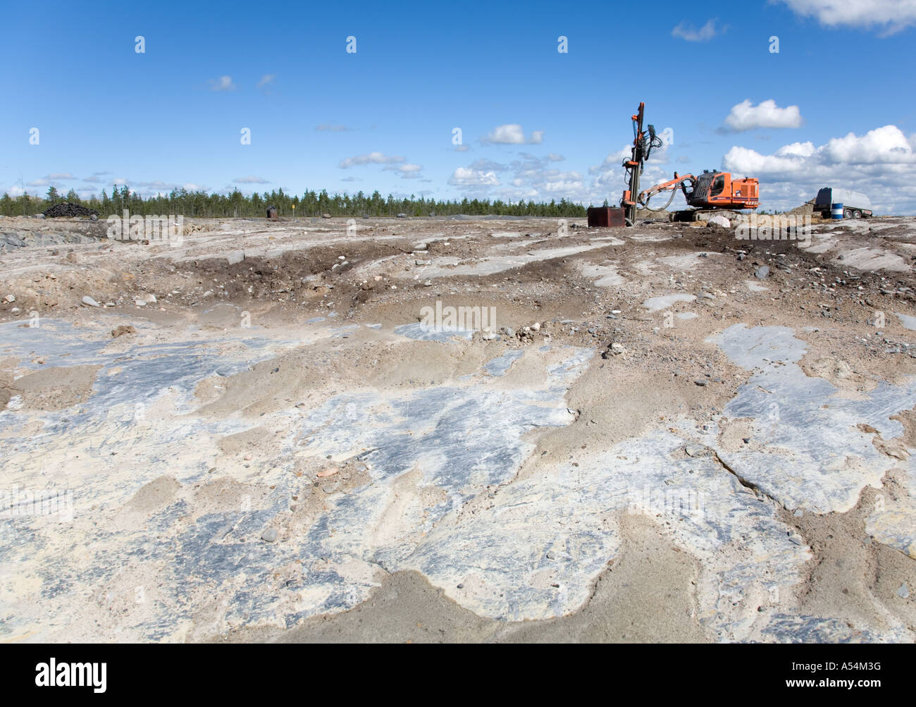 Orange Tamrock Ranger 780 rock drill machine in a rock quarry and the ...