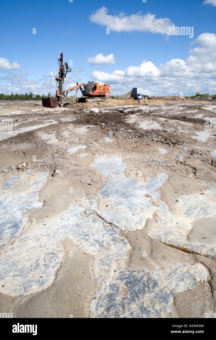 Orange Tamrock Ranger 780 rock drill machine in a rock quarry and the ...