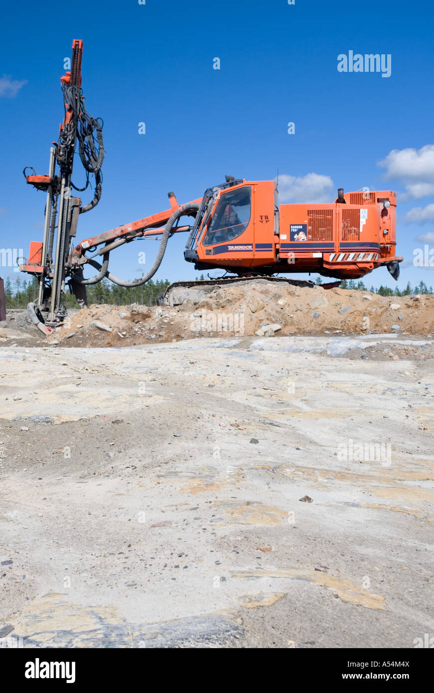 Orange Tamrock Ranger 780 rock drill machine in a rock quarry ready to ...
