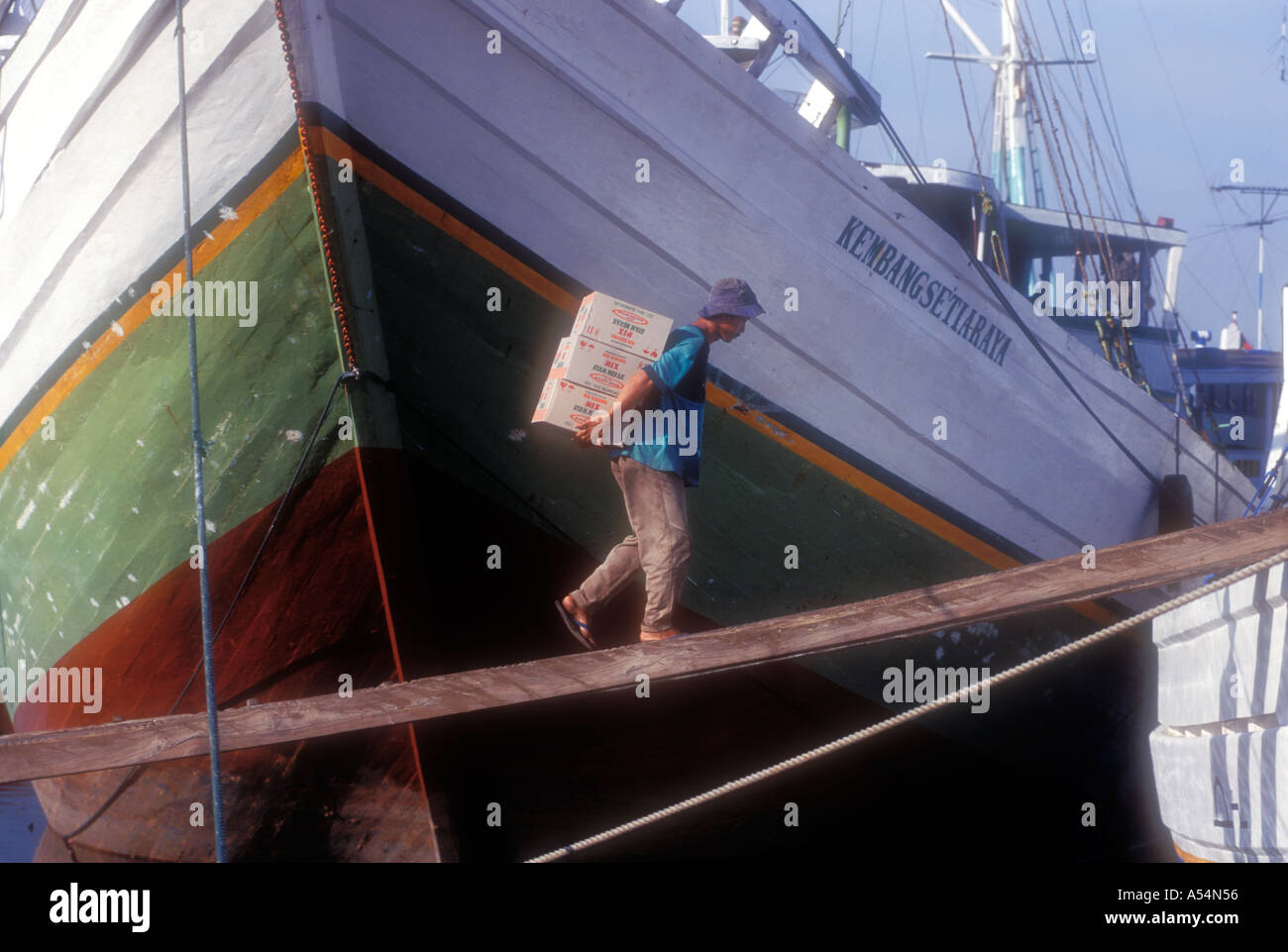 Worker carrying heavy load onto ship at Sunda Kelapa harbor in Jakarta ...