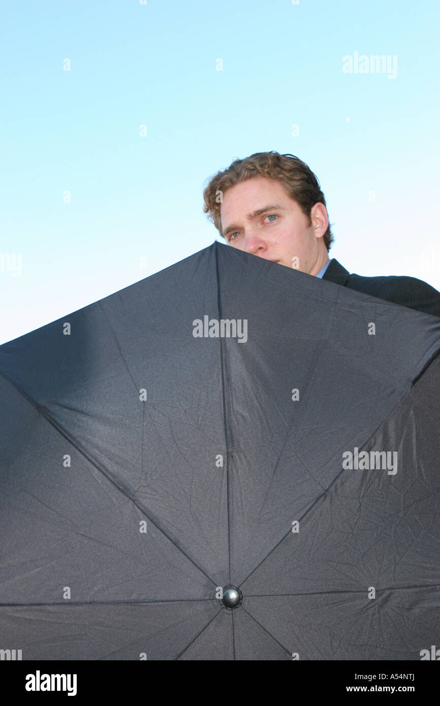 Businessman is holding umbrella with only his face showing Stock Photo ...