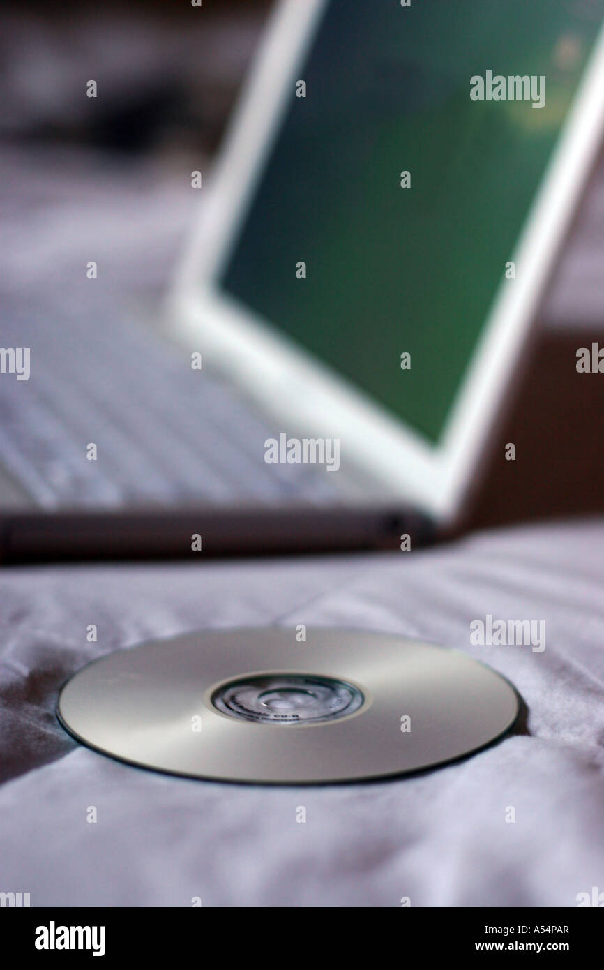 a blank dvd lies next to a white laptop Stock Photo - Alamy