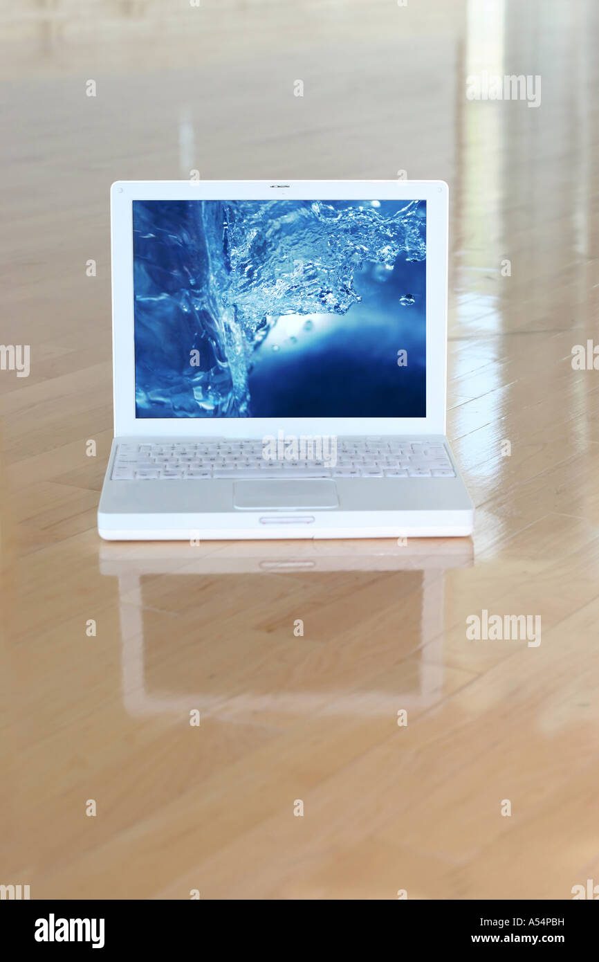 Laptop lies on the hardwood floor with nothing else around it. The ...