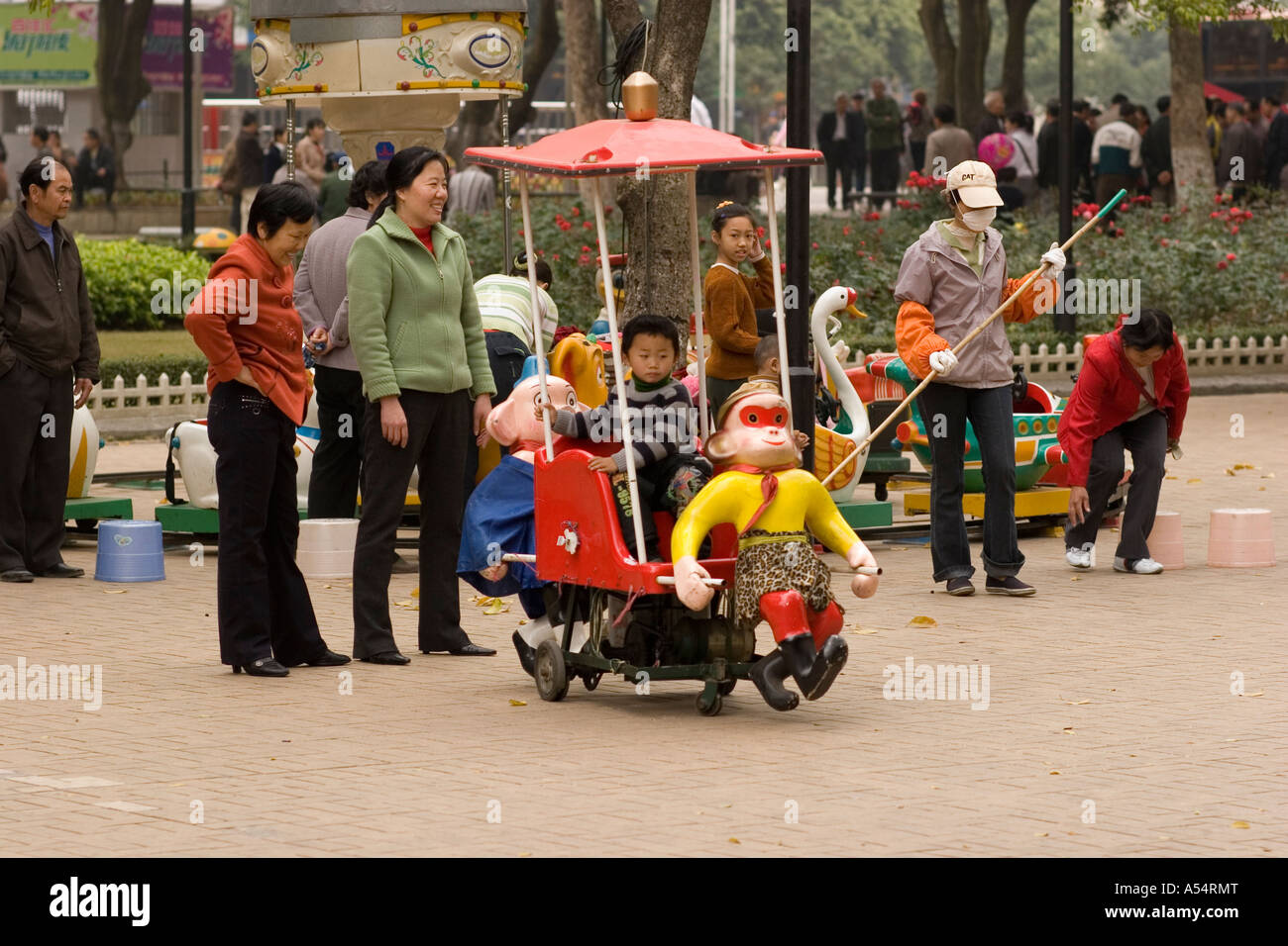 Children playing on ride in the park Nanning China Stock Photo - Alamy