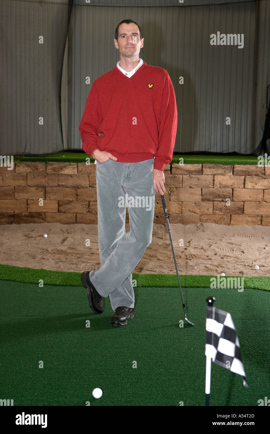 Golfer leaning on club Stock Photo - Alamy