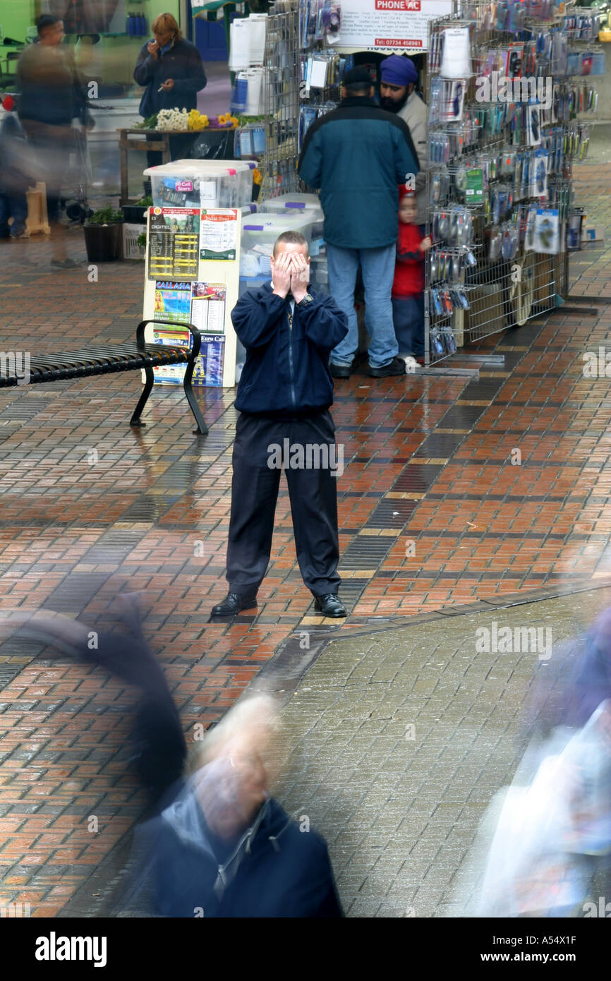 Single man stands alone and isolated amongst fast moving shoppers in ...