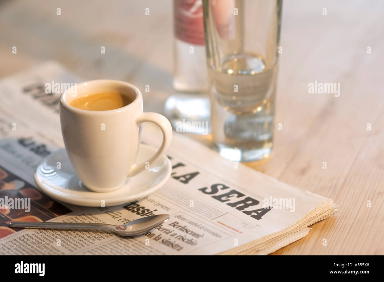 Italian cafe espresso coffee with newspaper and Grappa Stock Photo - Alamy