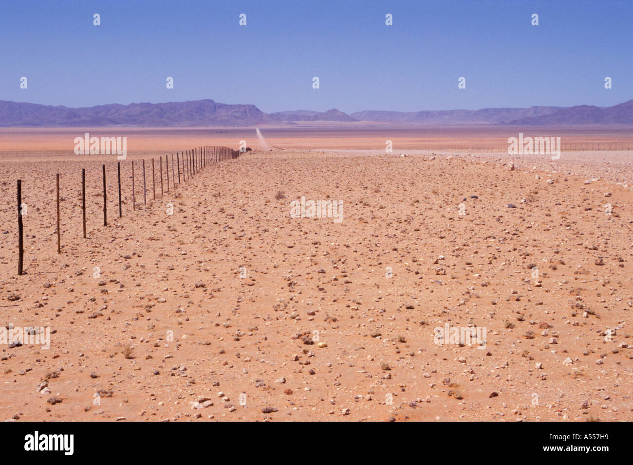 Gravel road and fence Namibia Stock Photo - Alamy