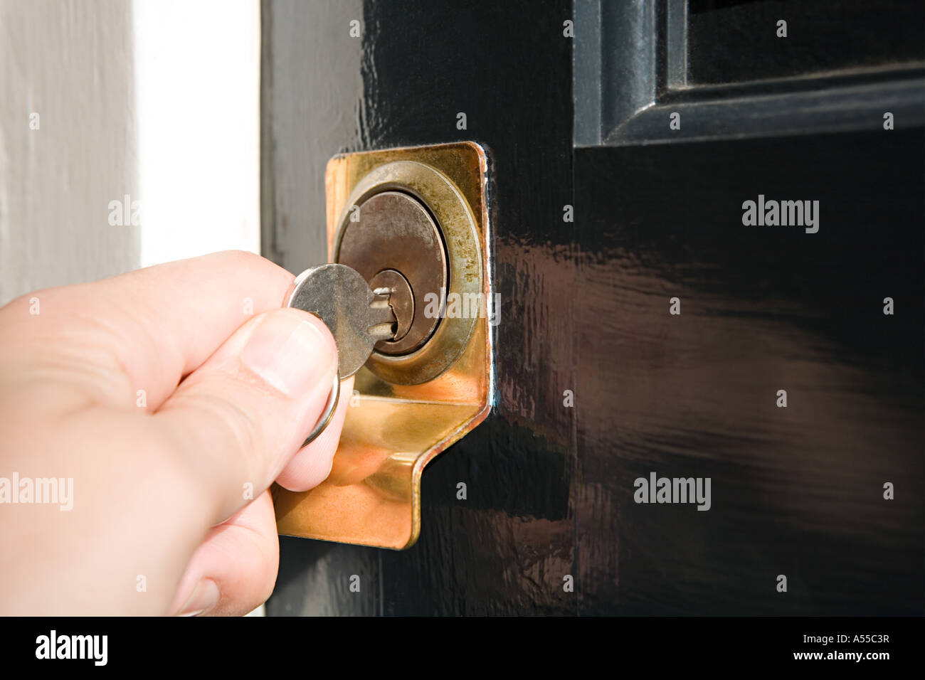 Person putting key in keyhole Stock Photo - Alamy