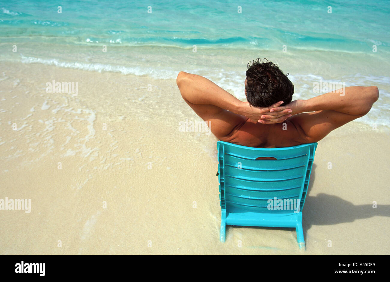 Man relaxing on beach chair Stock Photo - Alamy