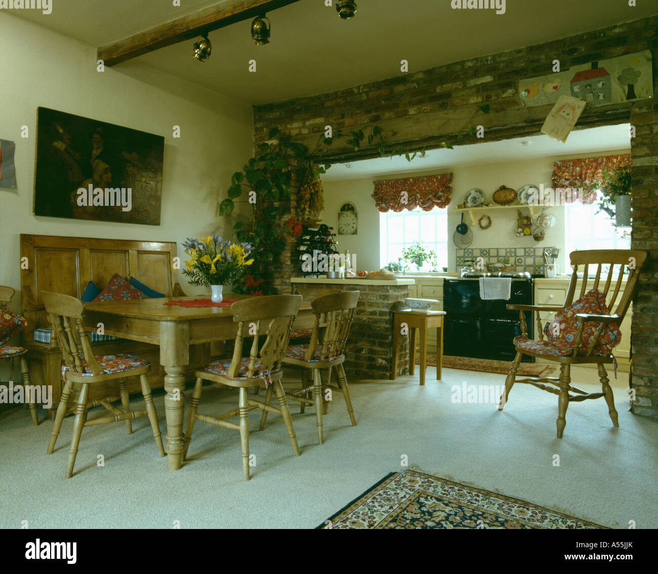 Pine settle and dining table and chairs in country kitchen with rug on ...