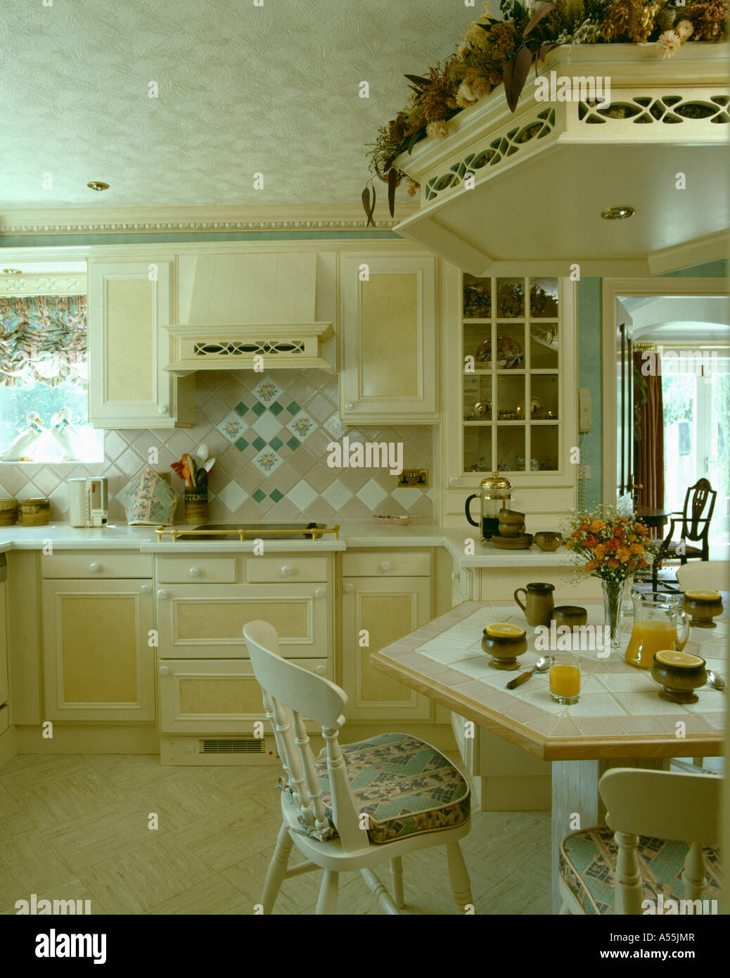 Breakfast settings on tiled worktop in neutral eighties kitchen Stock ...