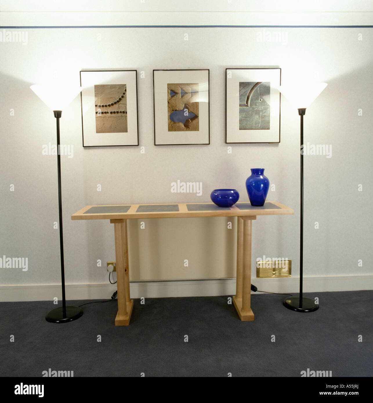 Pictures above table with standard lamps in modern hall Stock Photo - Alamy