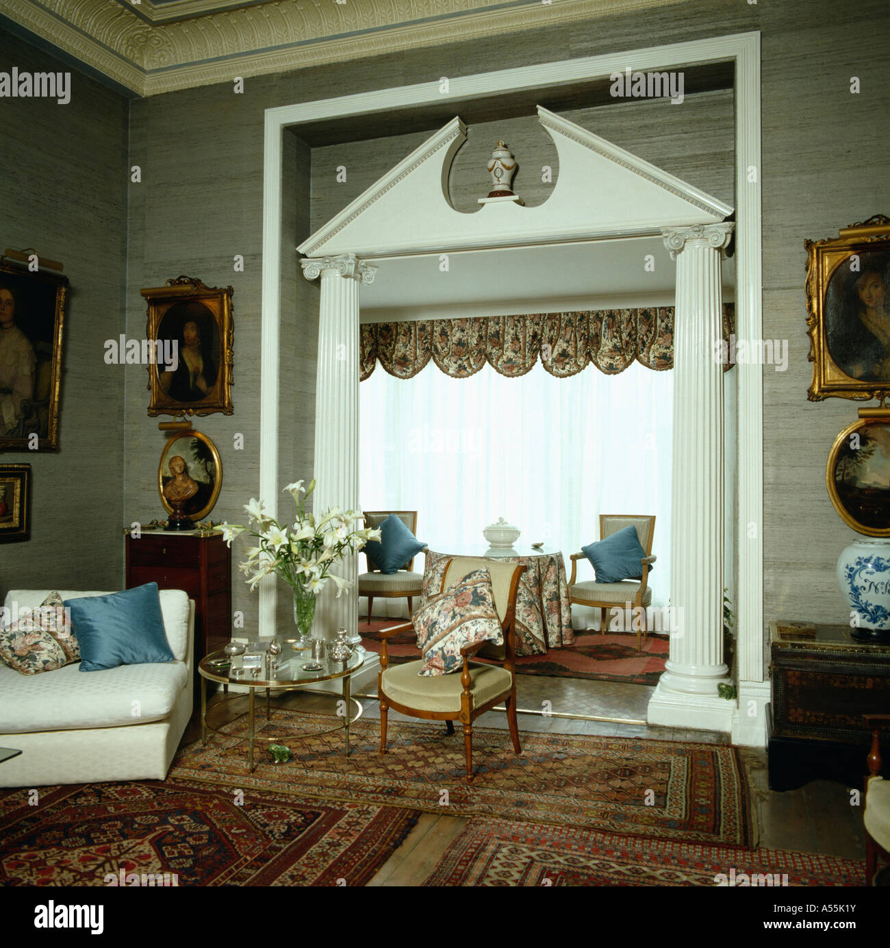 Ornate pediment above and pillars around townhouse drawing room with ...